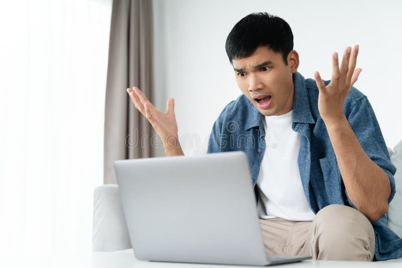 Shocked Surprised Asian Man Looking At Laptop Computer Screen Sitting