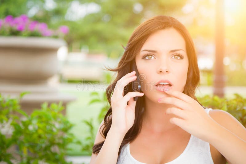 Shocked Young Adult Female Talking On Cell Phone Outdoors Stock Image