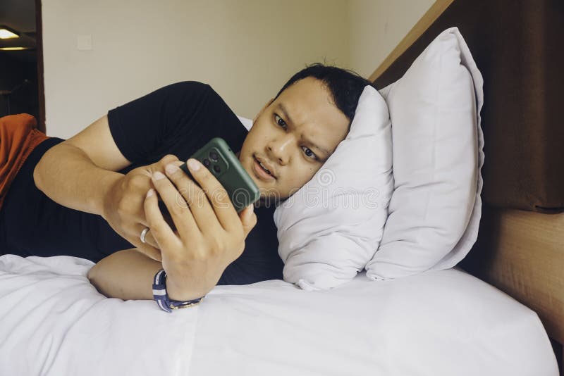 Shocked Young Man Checking on Her Phone while Lying in Bed Stock Image ...