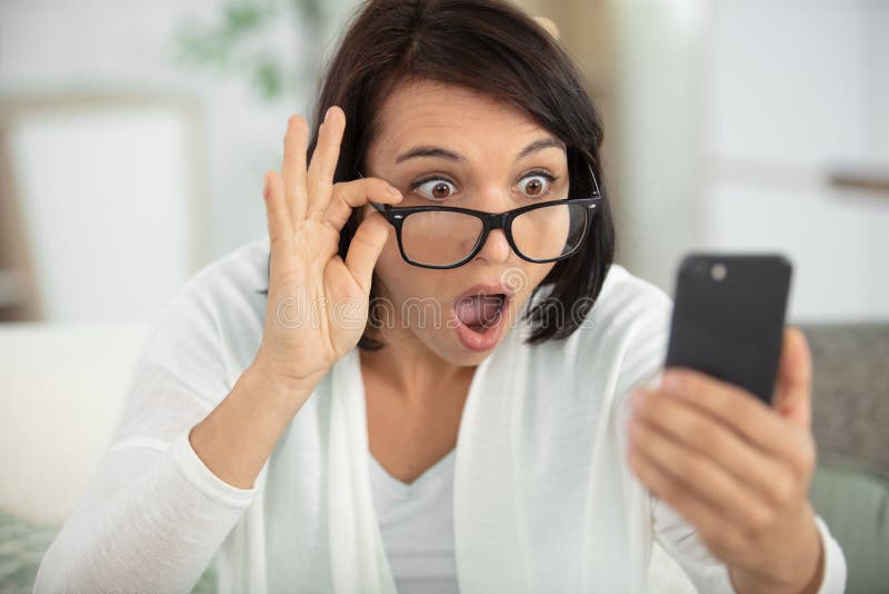 Shocked Young Woman Looking at Mobile Phone at Home Stock Image - Image ...