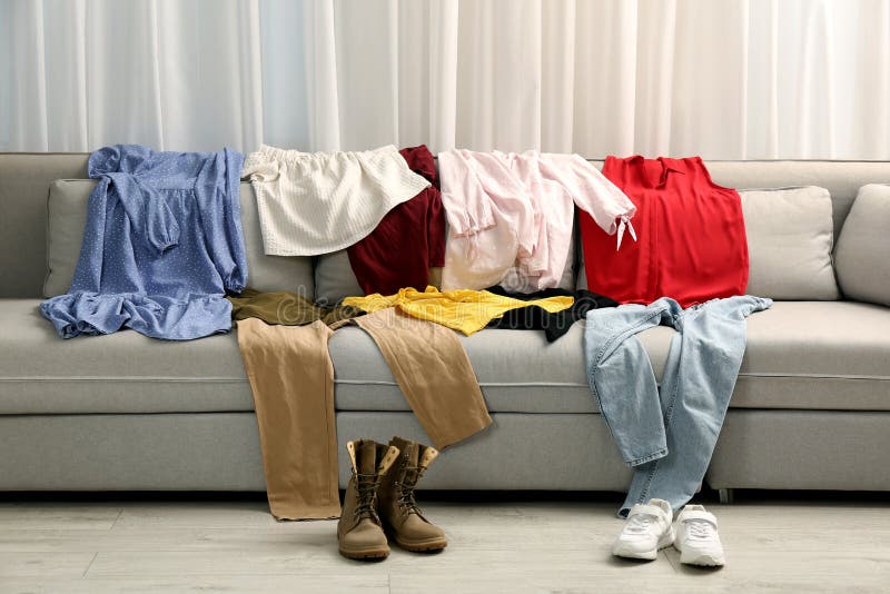 Shoes Near Sofa with Different Clothes Indoors Stock Image - Image of ...