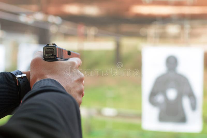 Shooting with a Pistol. Man Aiming Pistol in Shooting Range Stock Photo ...