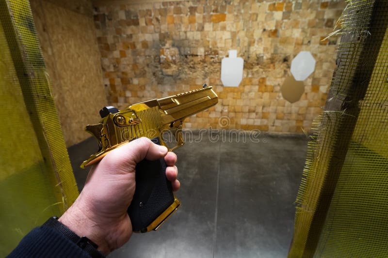 Shooting a Powerful Gold-colored Pistol at a Shooting Range Stock Photo ...
