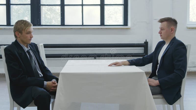 Two Men Sitting Facing Each Other in Waiting Stock Video - Video of ...