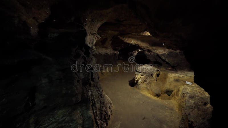 Shooting in an Underground Cave Illuminated by Lamps. Exploring a Stone ...