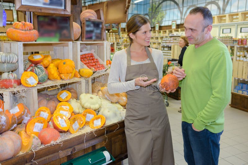 Shop Assistant Showing Pumpkin To Customer Stock Image - Image of show ...