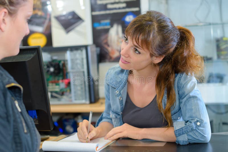 Shop Assistant Taking Notes from Customer Stock Photo - Image of women ...