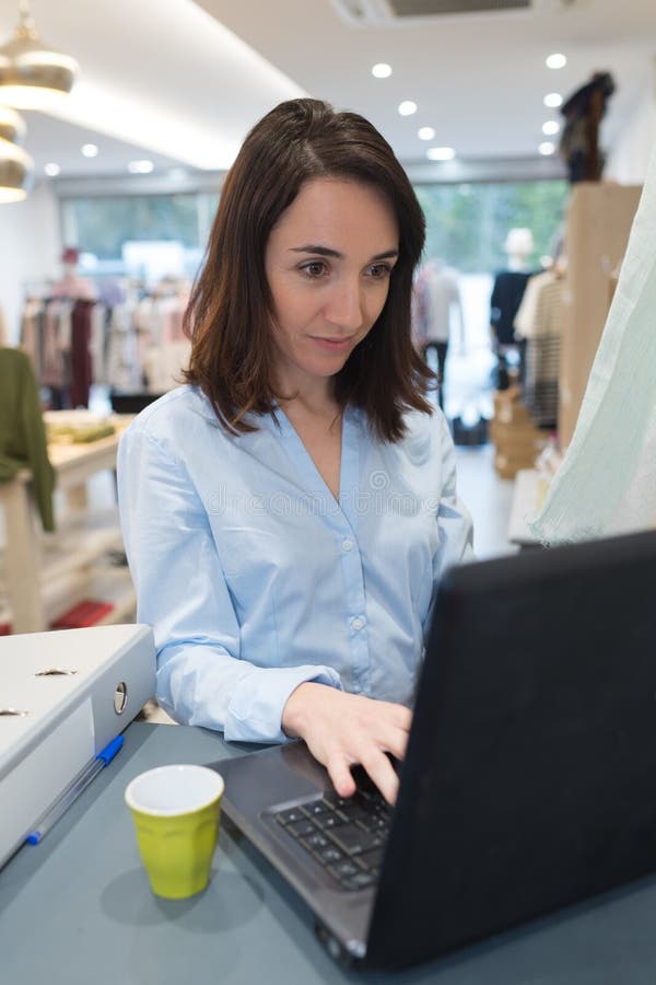 Shop Worker Using Laptop by Till Stock Photo - Image of centre ...