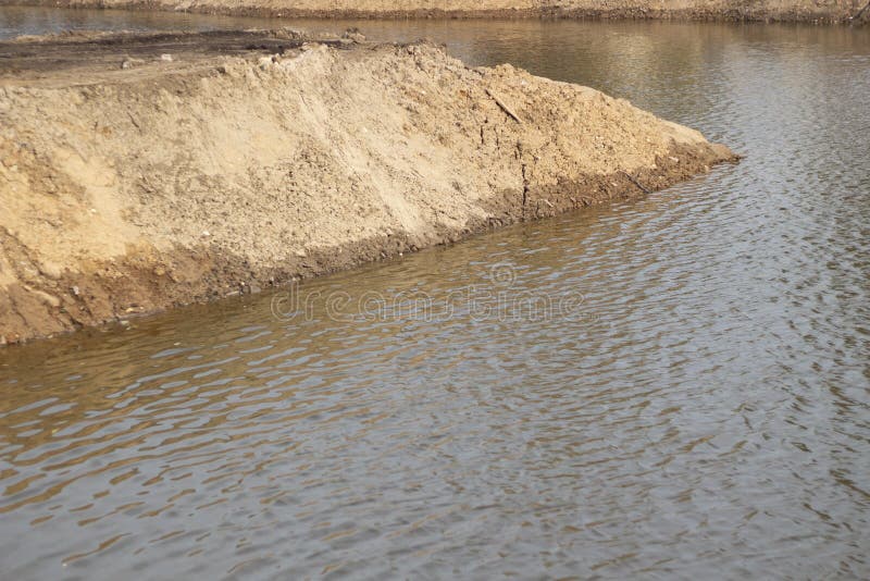 The Shore of an Artificial Pond. a Mound of Sand on the Water Stock ...