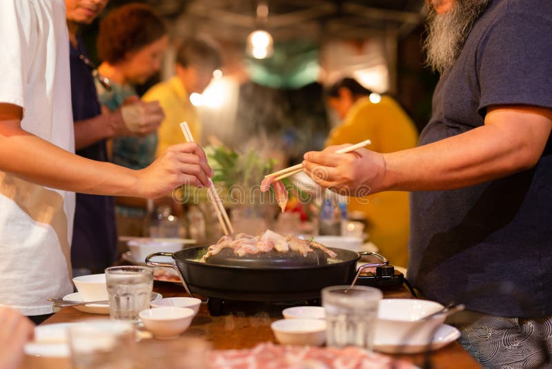 Short in Low Light Family Dinner Hand with Chopstick Cooking Pork Slice ...