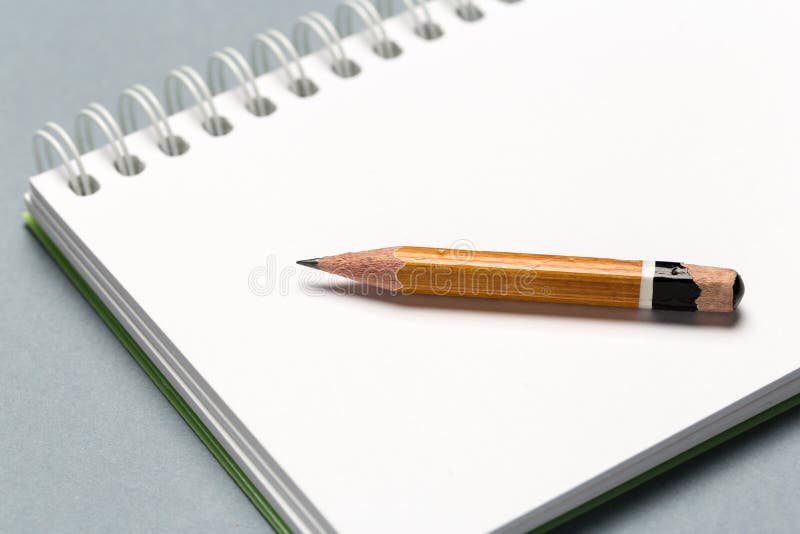 Short Worn Pencil with Notepad on Gray Desk Stock Photo - Image of ...