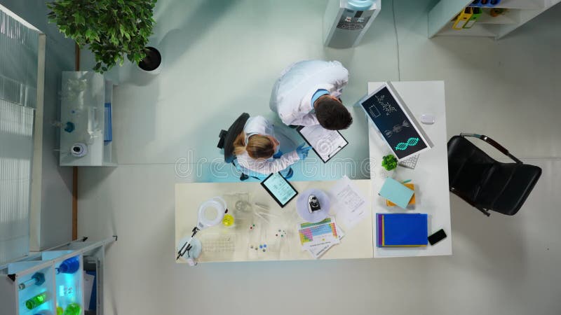 In a Shot from Above in a Lab of Two Scientists they are Both ...