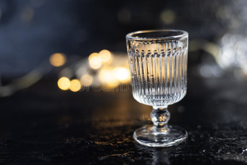 Shot Glasses Lay Empty in a Dark Room. the Back of the Glass Has Orange ...