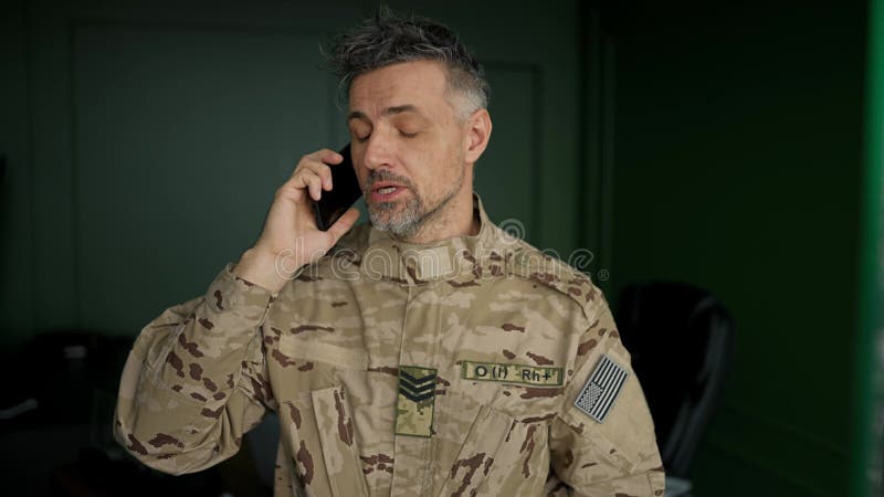 Shot of a Gray-haired Soldier in Camouflage Who Speaks on the Phone ... Shot of a Gray-haired Soldier in Camouflage Who Speaks on the Phone ...
