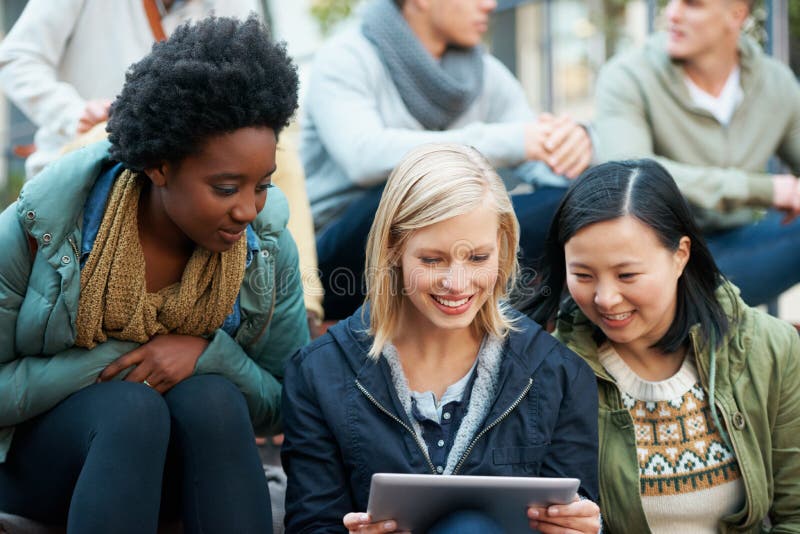 Look at this. Shot of a Group of University Students Looking at ...