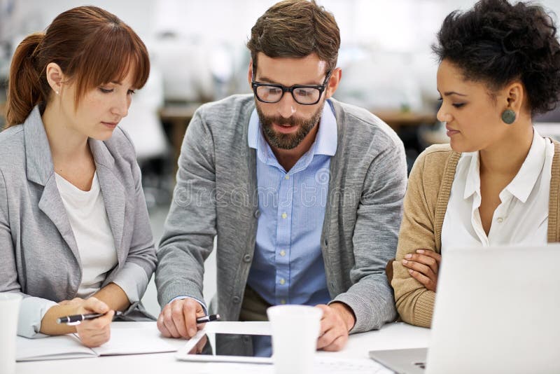 Working through Digital Paperwork. Shot of a Group of Young Office ...
