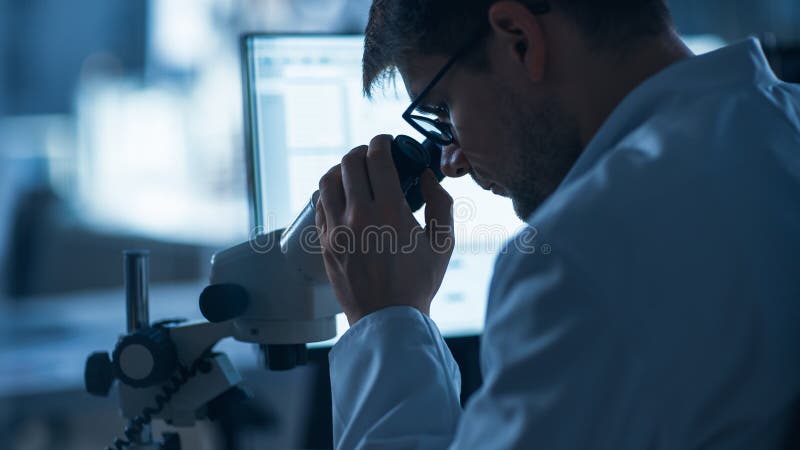 Shot of a Male it Scientist Uses Computer with Electronic Microscope ...