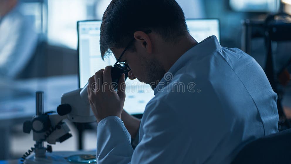 Shot of a Male it Scientist Uses Computer with Electronic Microscope ...