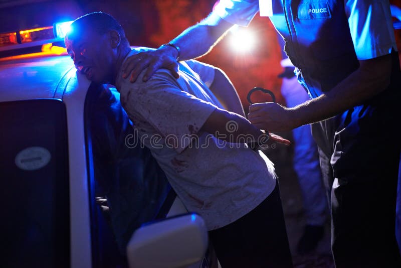 To Serve And Protect Shot Of A Police Officer Handcuffing A Suspect