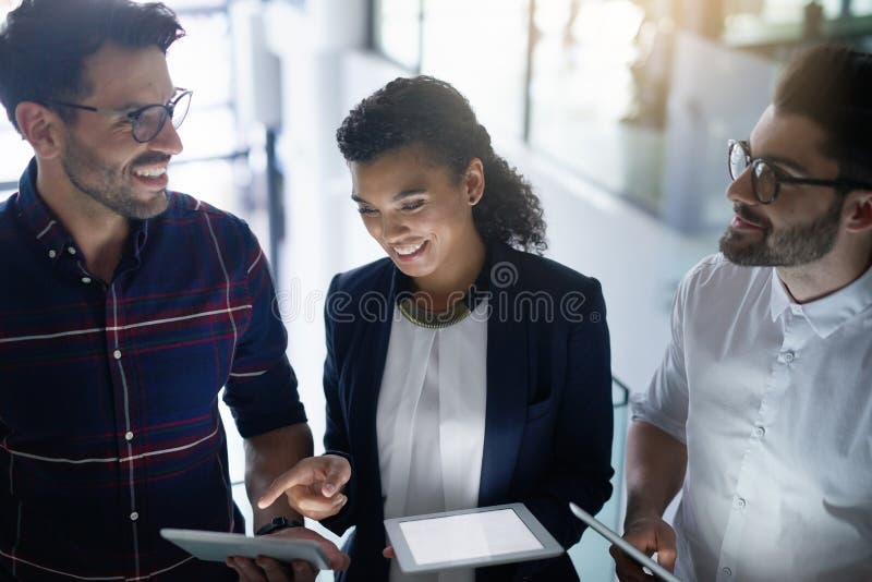 Utilizing Technology As a Team. Shot of Three Colleagues Using Digital ...