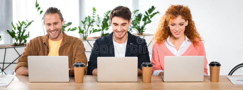 Shot of Three Smiling Friends Using Laptops in Office Stock Image ...