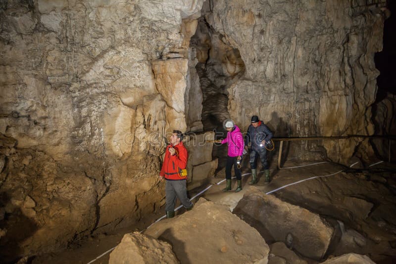 Shot of Two Tourists and a Tourist Guide Walking in the Cave Stock ...