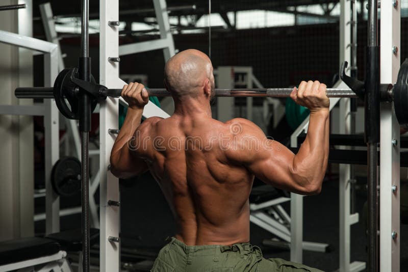 Shoulder Exercises on a Smith Machine Stock Image - Image of indoors ...
