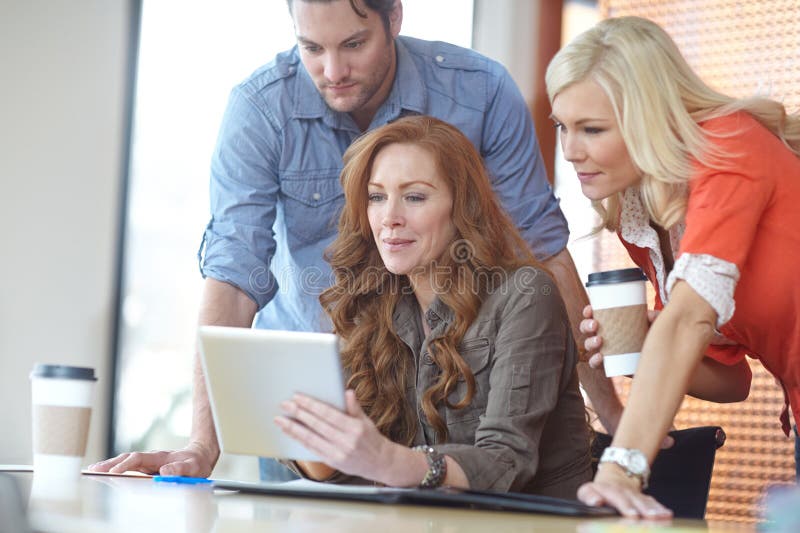 Showing Off Her New Tablet at Work. a Group of Three Colleagues Looking ...