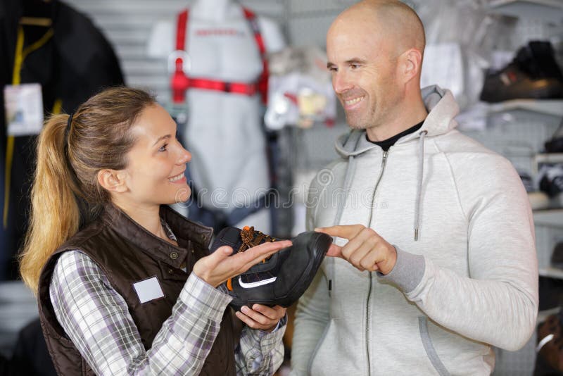 Showing shoe to customer stock photo. Image of employee - 99537930