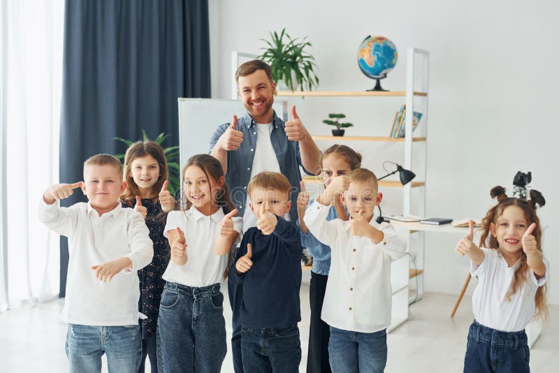 Showing Thumbs Up. Group of Children Students in Class at School with ...