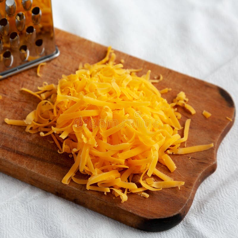 Shredded Sharp Cheddar Cheese on a Rustic Wooden Board, Low Angle View ...
