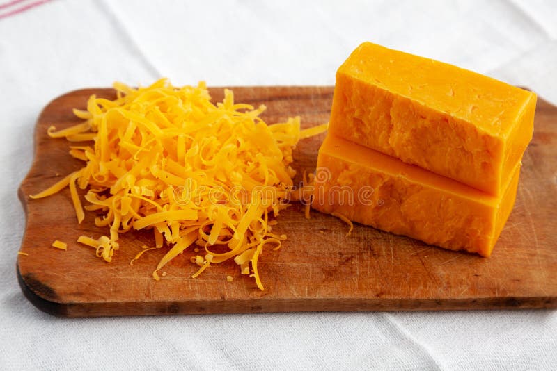 Shredded Sharp Cheddar Cheese on a Rustic Wooden Board, Side View Stock ...