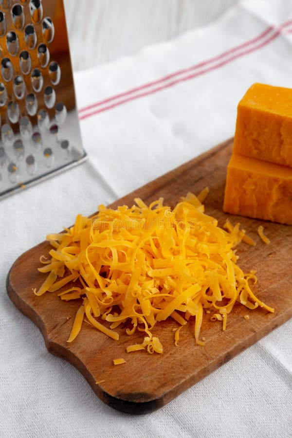 Shredded Sharp Cheddar Cheese on a Rustic Wooden Board, Side View Stock ...