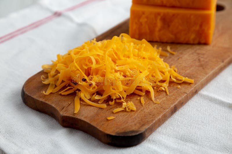 Shredded Sharp Cheddar Cheese on a Rustic Wooden Board, Side View Stock ...