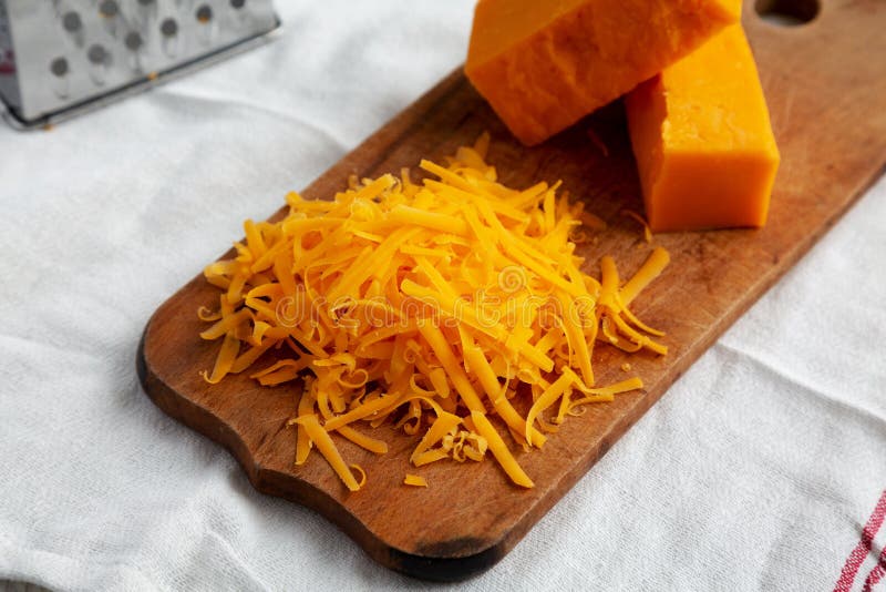 Shredded Sharp Cheddar Cheese on a Rustic Wooden Board, Side View Stock ...