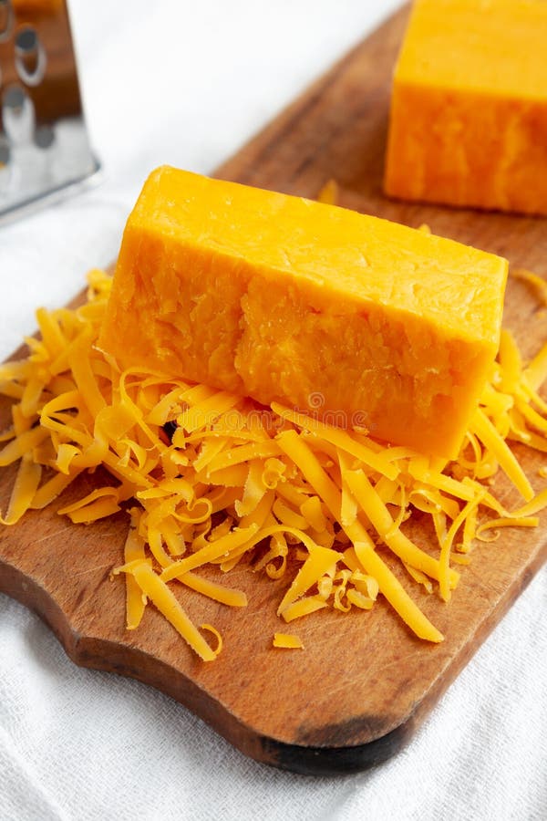 Shredded Sharp Cheddar Cheese on a Rustic Wooden Board, Side View Stock ...