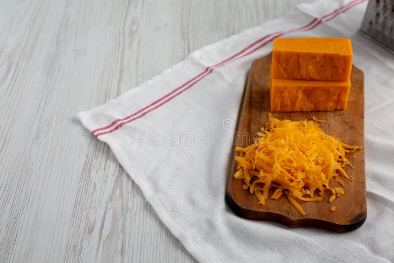 Shredded Sharp Cheddar Cheese on a Rustic Wooden Board, Side View. Copy ...
