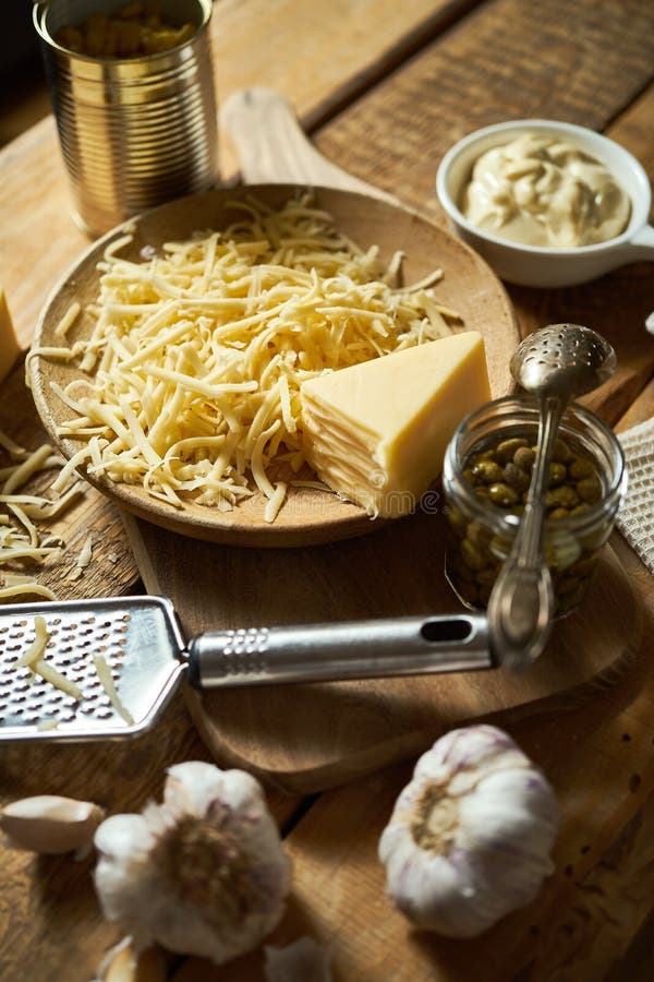 Shredded Yellow Cheese with Cheese Grater and Capers and Basil on ...
