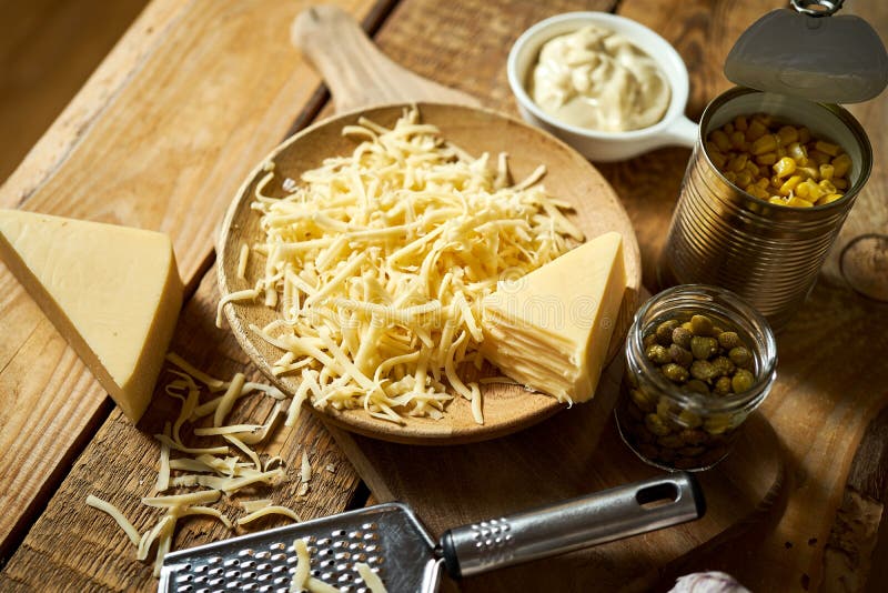 Shredded Yellow Cheese with Cheese Grater and Capers and Basil on ...
