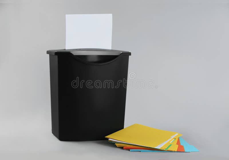 Shredder with Sheet of Paper and Colorful Folders on Grey Background ...