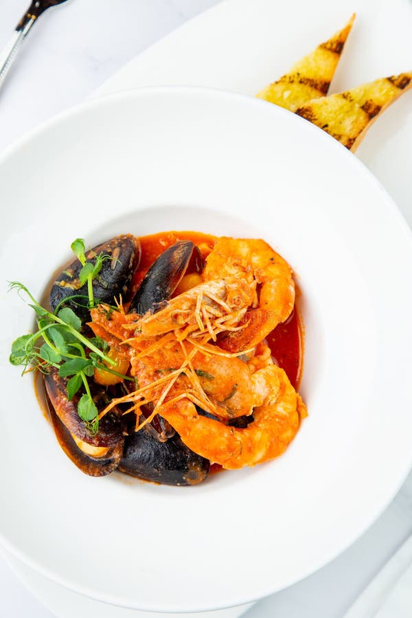Shrimp and Mussels with Herbs in a White Plate with Toasted Bread, Side ...