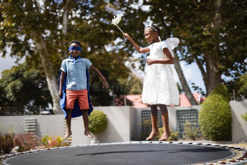 Siblings in Costumes Jumping on Trampoline Stock Image - Image of male ...