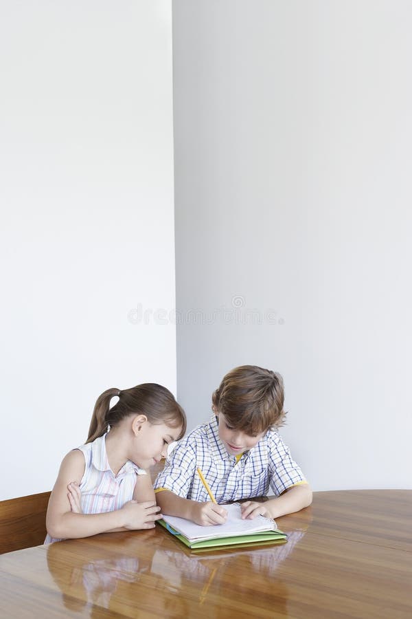 Siblings Doing Homework at Table Stock Photo - Image of leisure ...