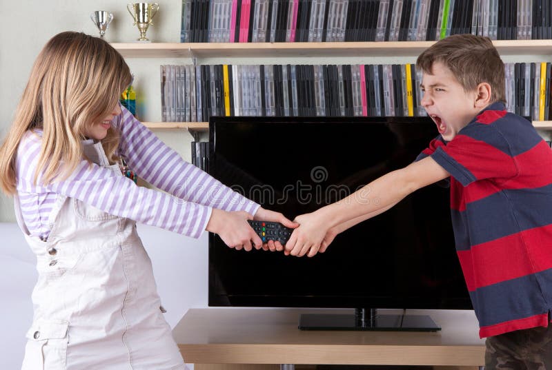 Siblings Fighting Over the Remote Control in Front of the TV Stock ...