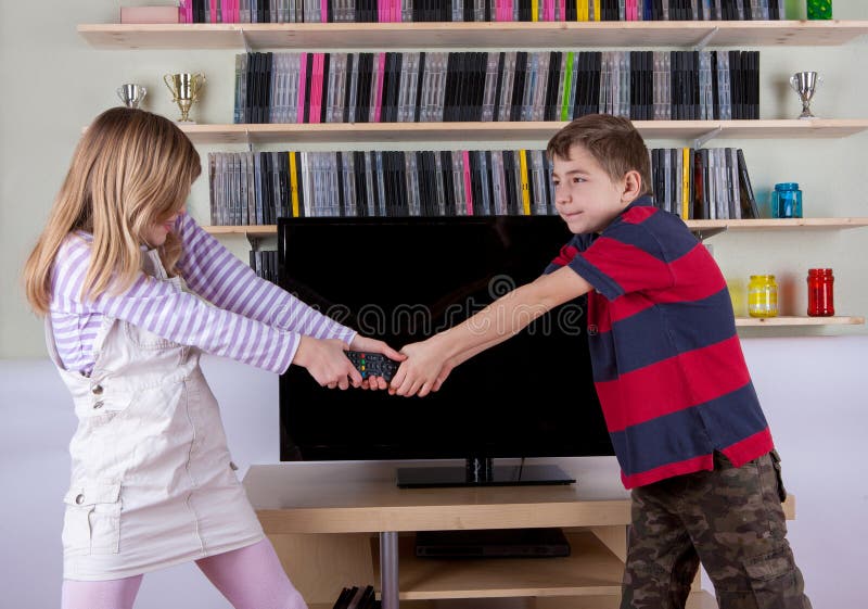 Siblings Fighting Over the Remote Control in Front of the TV Stock ...