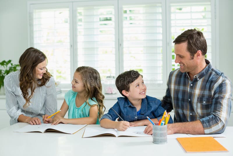 Siblings Getting Help with Homework from Parents Stock Photo - Image of ...