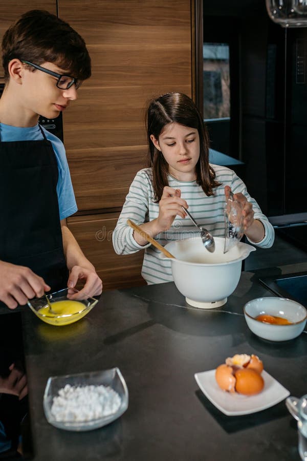 Siblings Preparing a Cake, Adding Sugar and Whisking Eggs in the ...