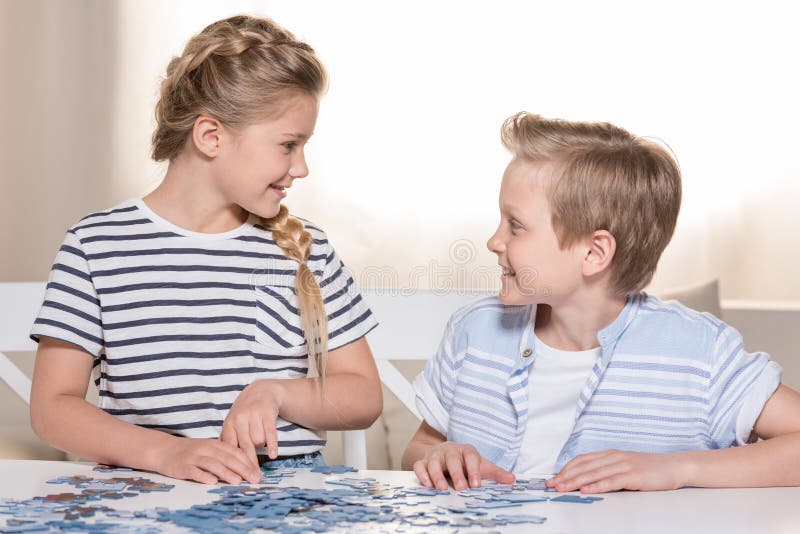 Siblings Playing with Puzzle on Table at Home Together Stock Photo ...