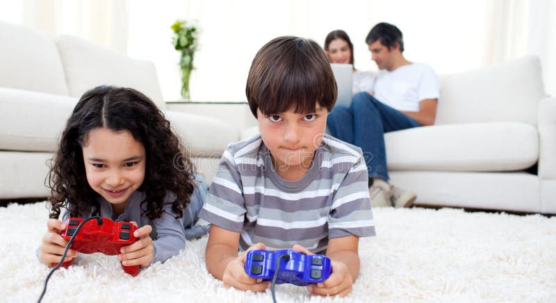 Siblings Playing Video Games Together Stock Photo - Image of lying ...