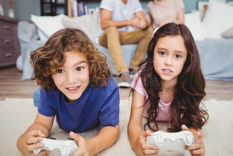 Siblings with Remote Playing Video Games on Carpet Stock Photo - Image ...